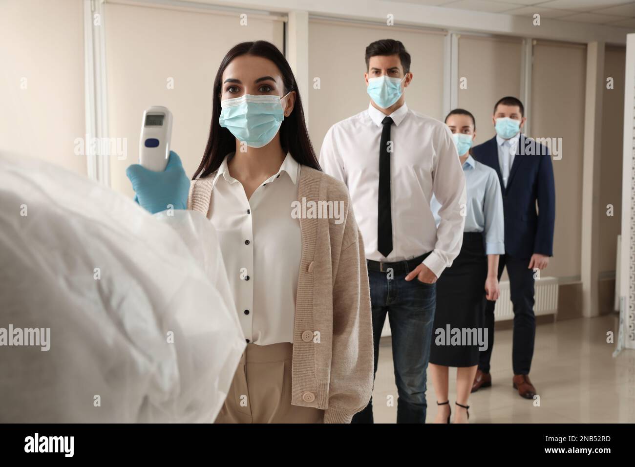Doctor measuring employees temperature in office, closeup. Prevent ...