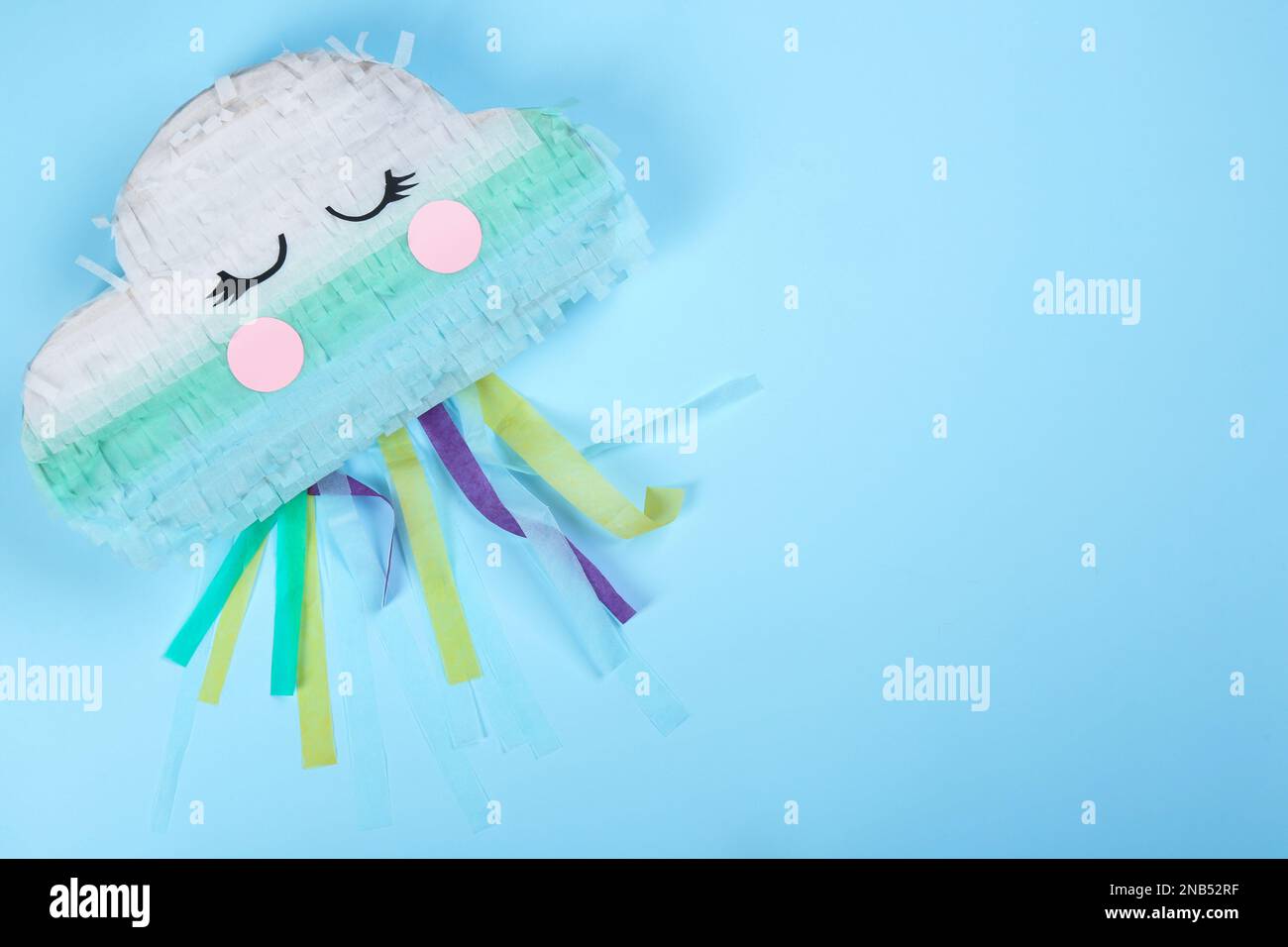 Bright cloud pinata on light blue background, top view. Space for text ...