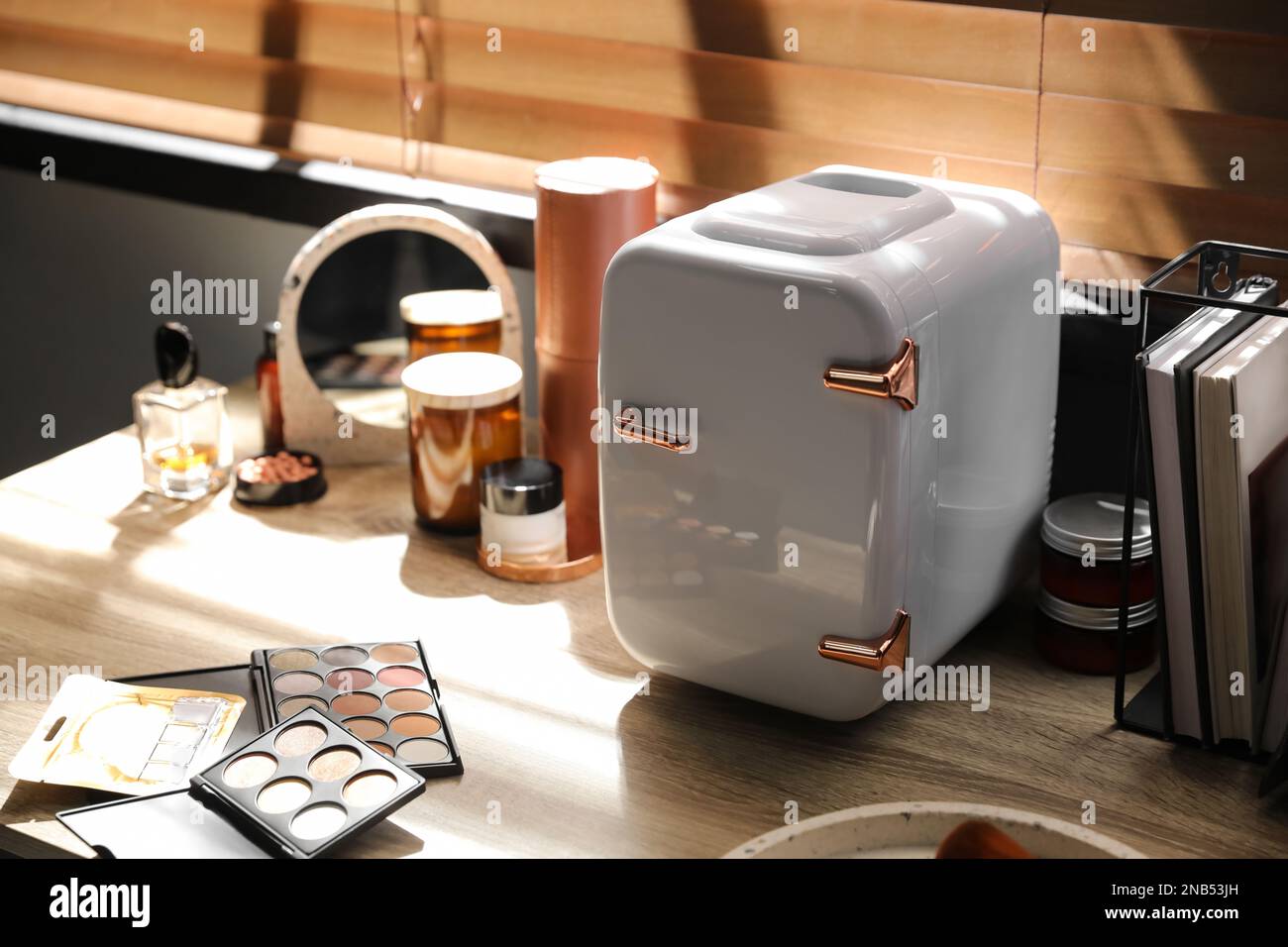 Mini fridge for cosmetic products on wooden vanity table Stock Photo ...