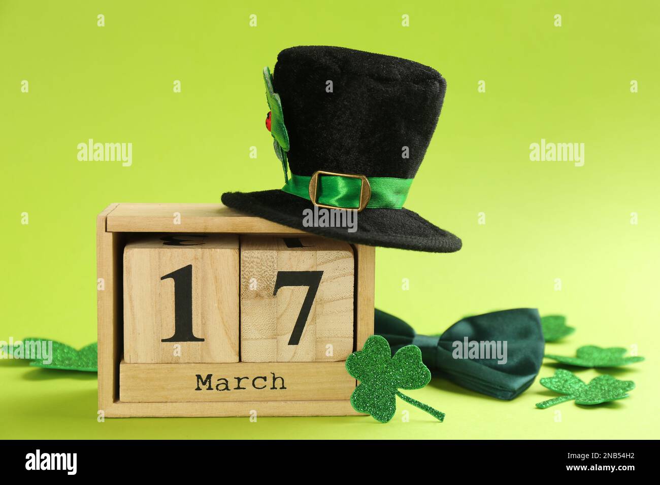 Leprechaun's hat, block calendar and St. Patrick's day decor on green ...