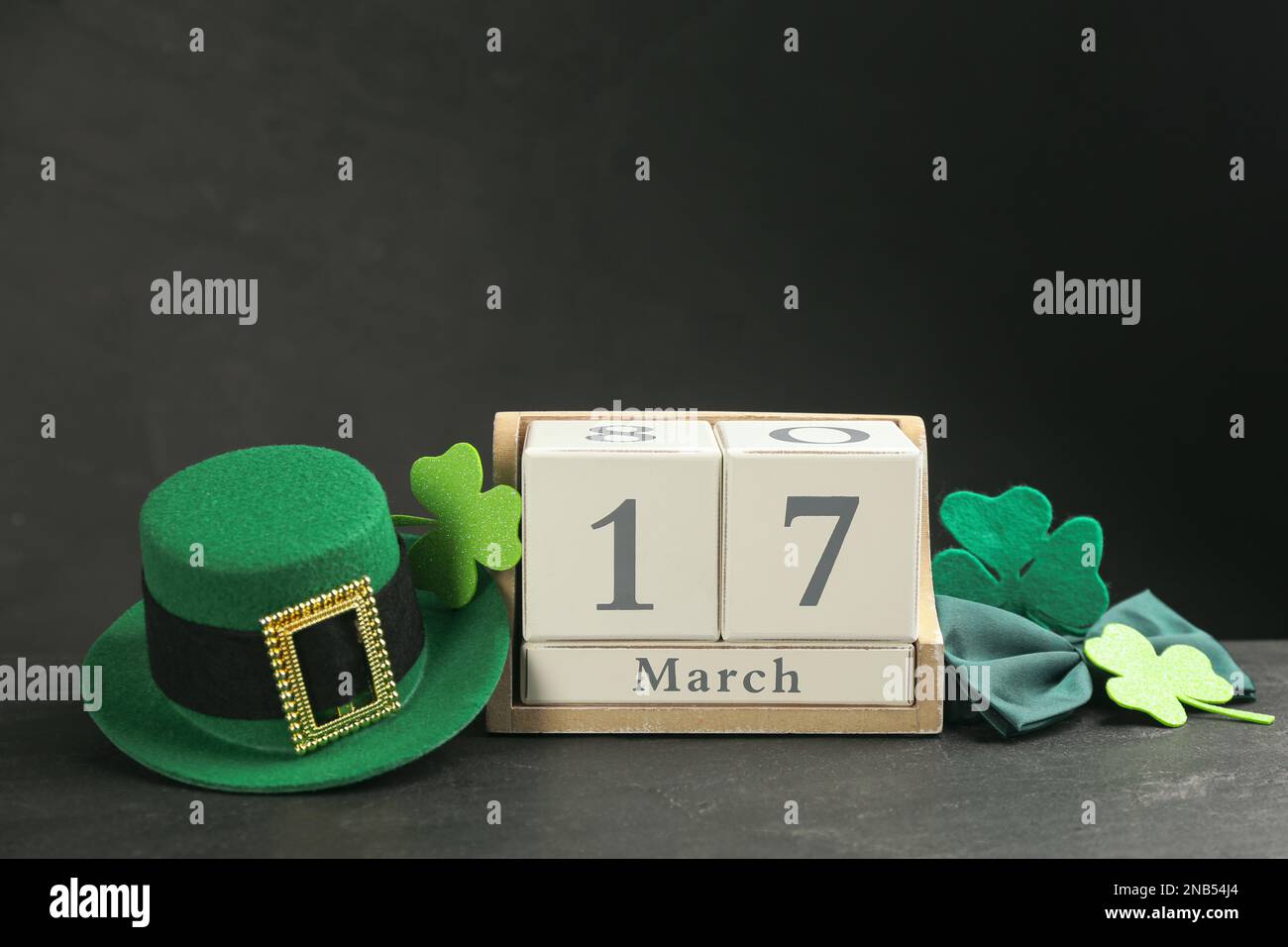Leprechaun's hat, block calendar and St. Patrick's day decor on black ...