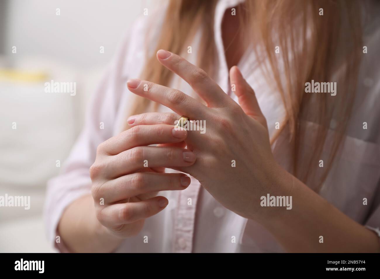 Woman taking off wedding ring indoors, closeup. Divorce concept Stock ...