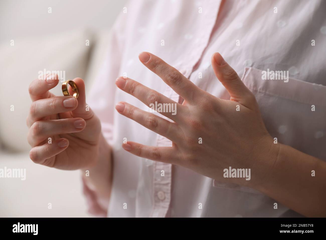 Woman taking off wedding ring indoors, closeup. Divorce concept Stock ...