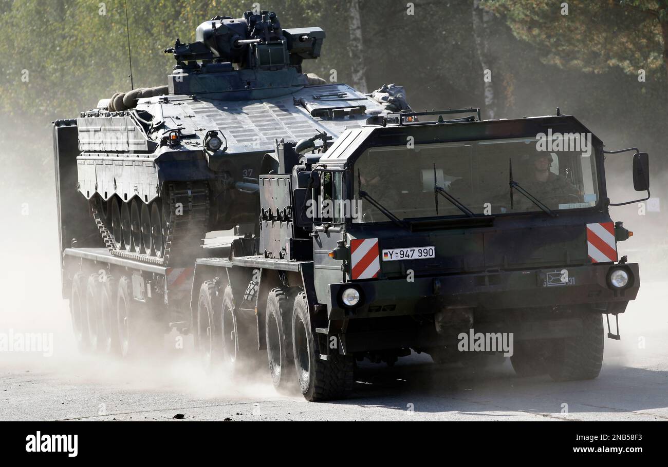 A transportation truck carries a Boxer armoured transport vehicle ...