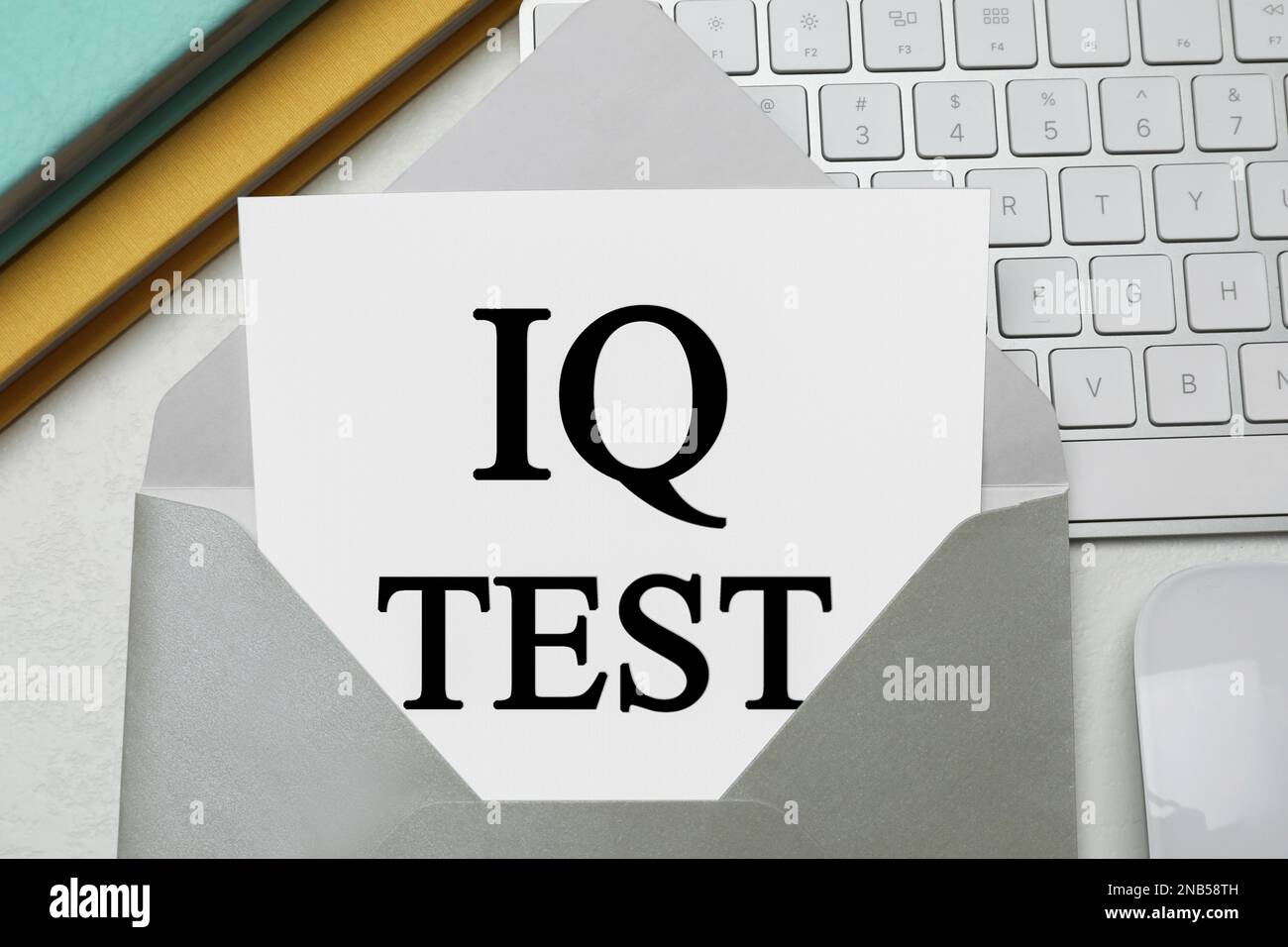 Paper with words IQ Test in envelope and keyboard on office table, flat ...