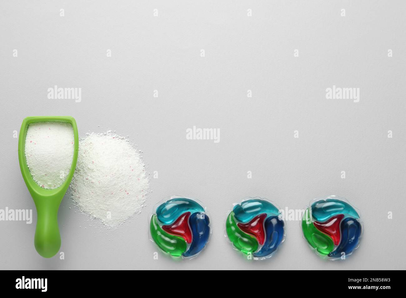 Laundry capsules and detergent powder on light grey background, flat ...