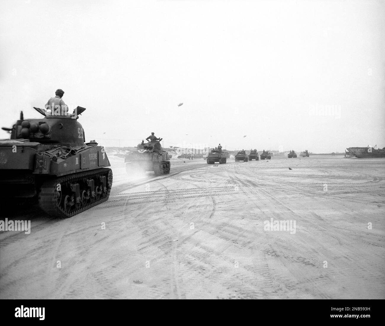 French soldiers driving American tanks from an LST onto a beach ...