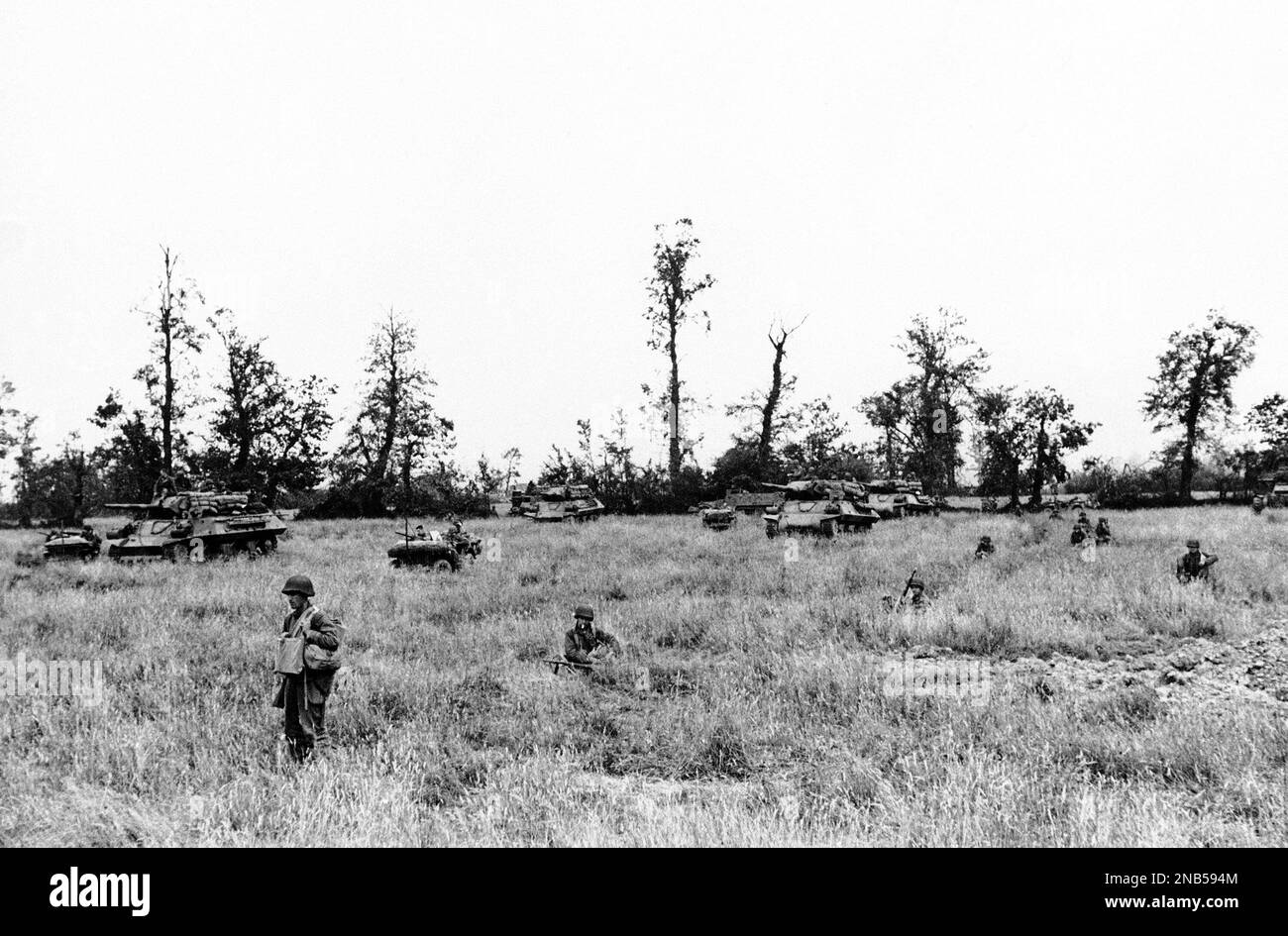 American infantrymen advance through a wheat field, south of St. Lo, in ...