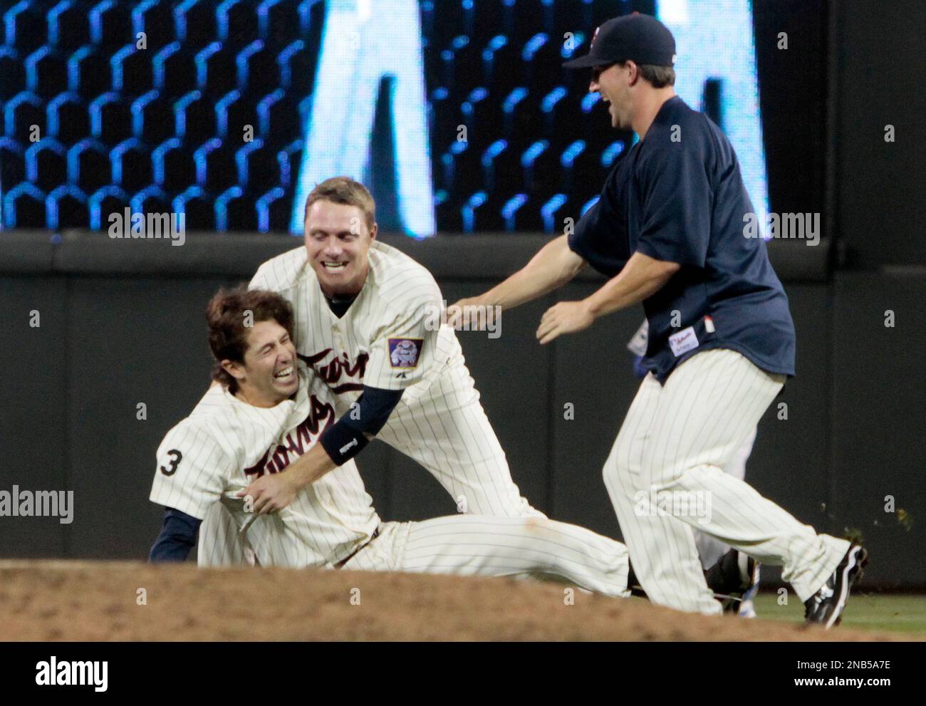 Minnesota Twins' Luke Hughes, center, and Brian Dinkelman, right ...
