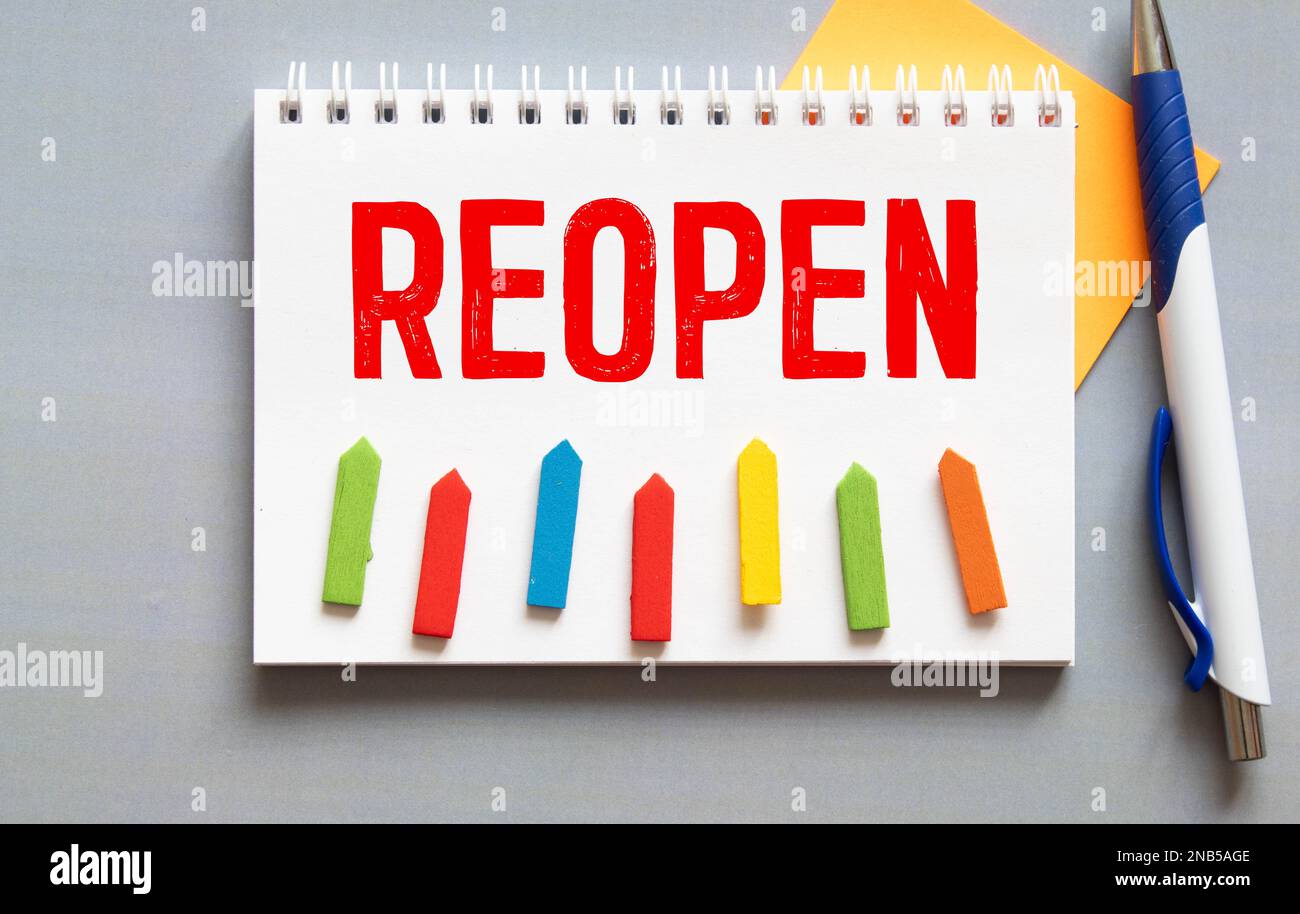 Yellow note paper with word reopening on cork board background with ...