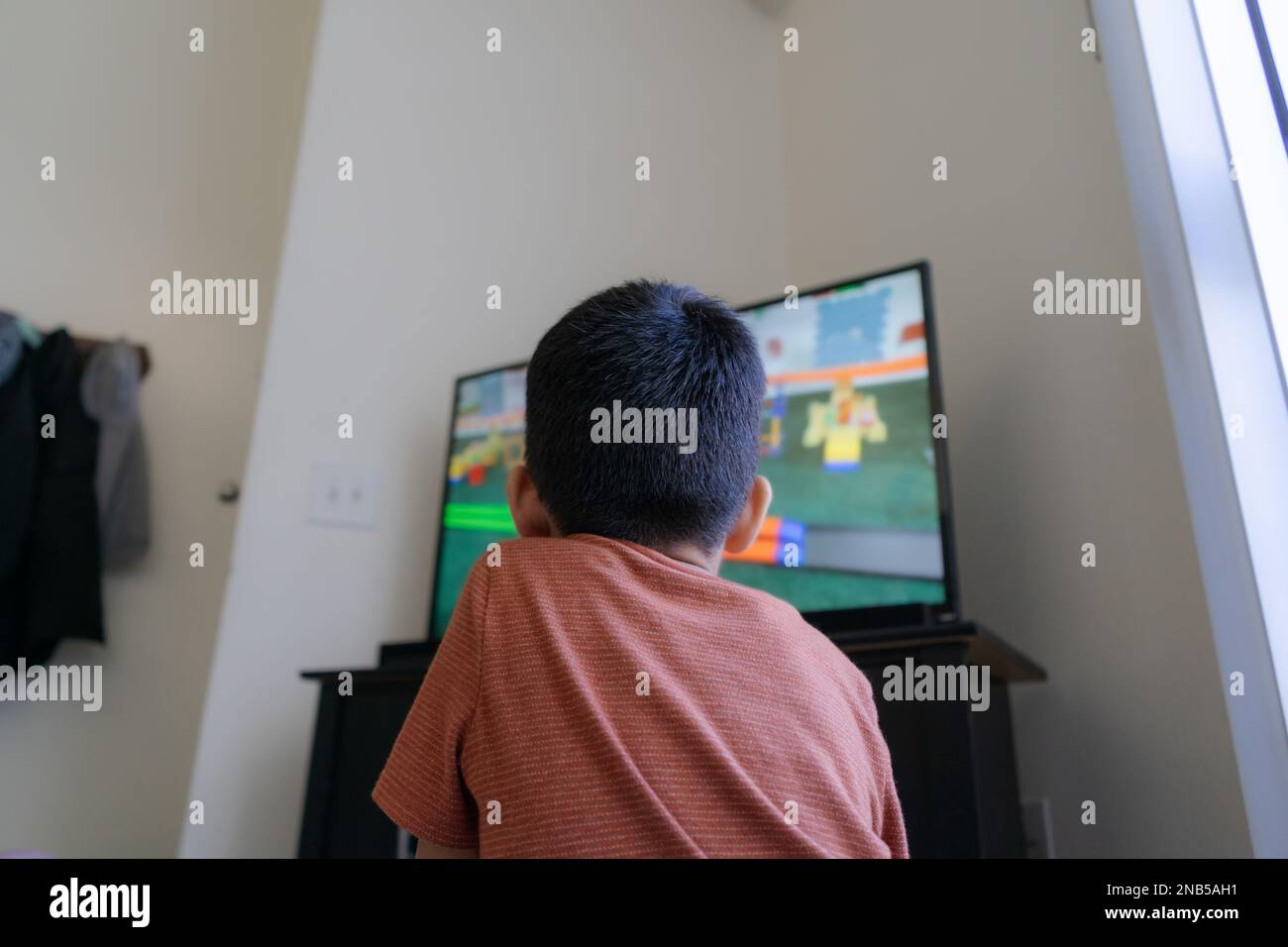 Young Child watching a show on a flat screen television in the living ...