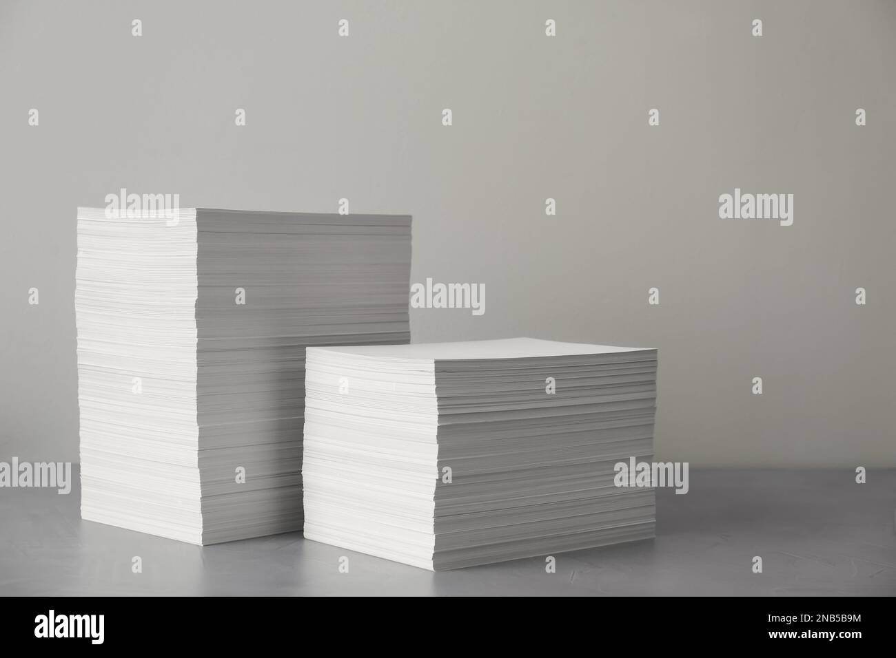Stacks of paper sheets on grey table Stock Photo - Alamy