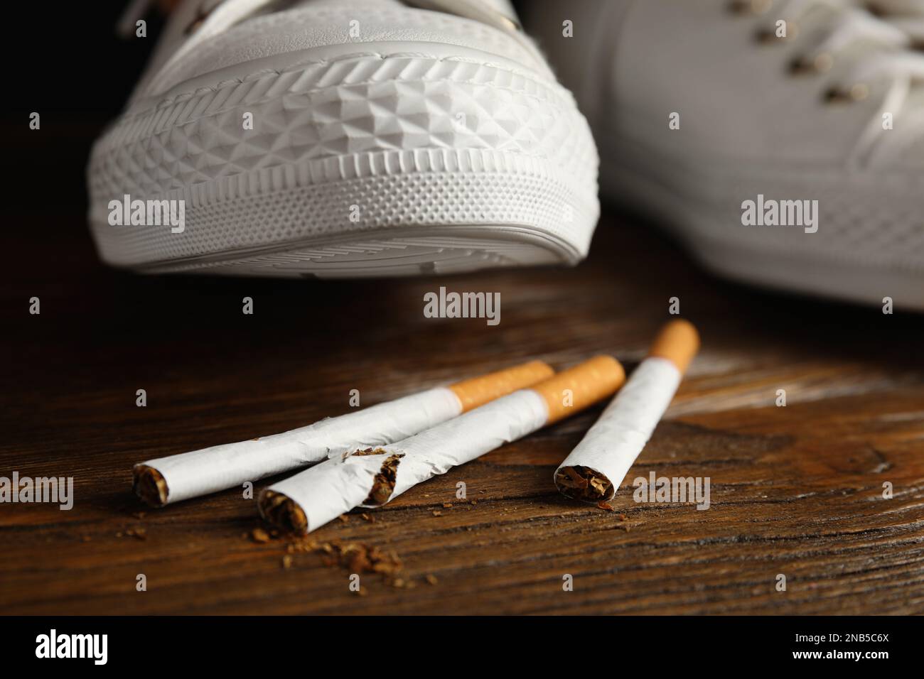 Woman stepping on pile of cigarettes, closeup. Quitting smoking concept ...