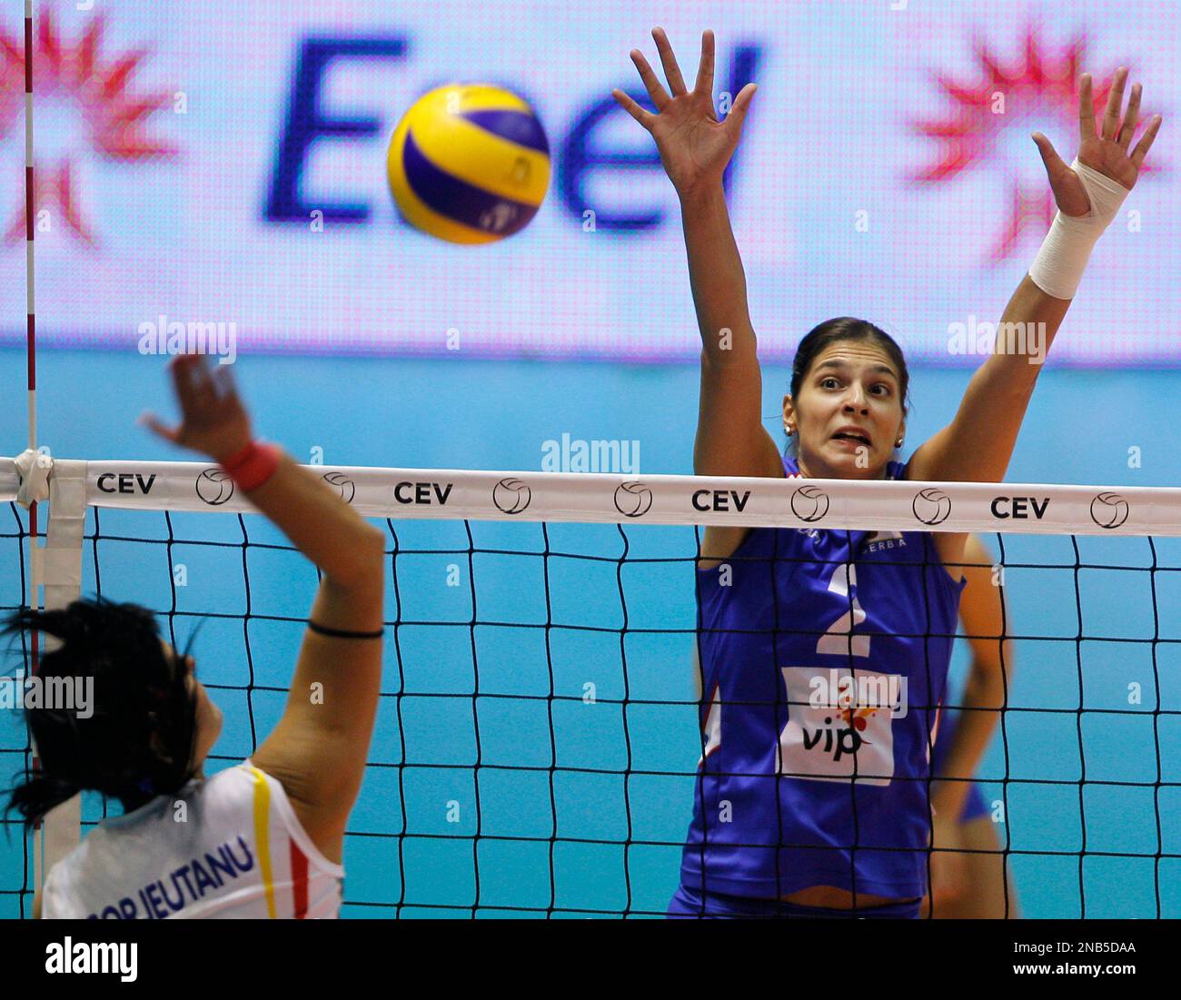 Romania's Mirela Corjeutanu, left, spikes the ball against Serbia's ...