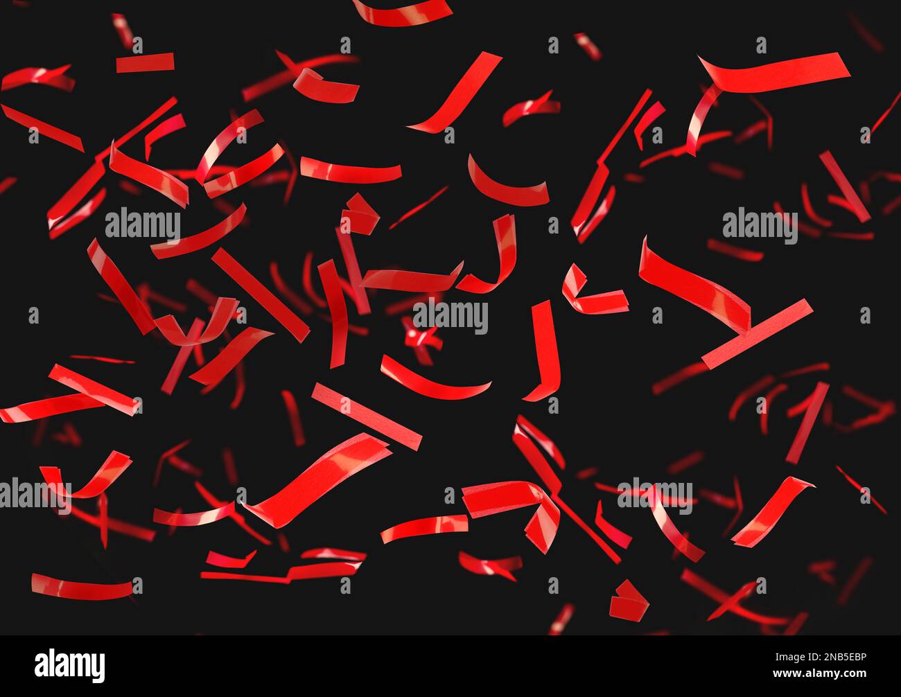 Shiny red confetti falling down on black background Stock Photo - Alamy