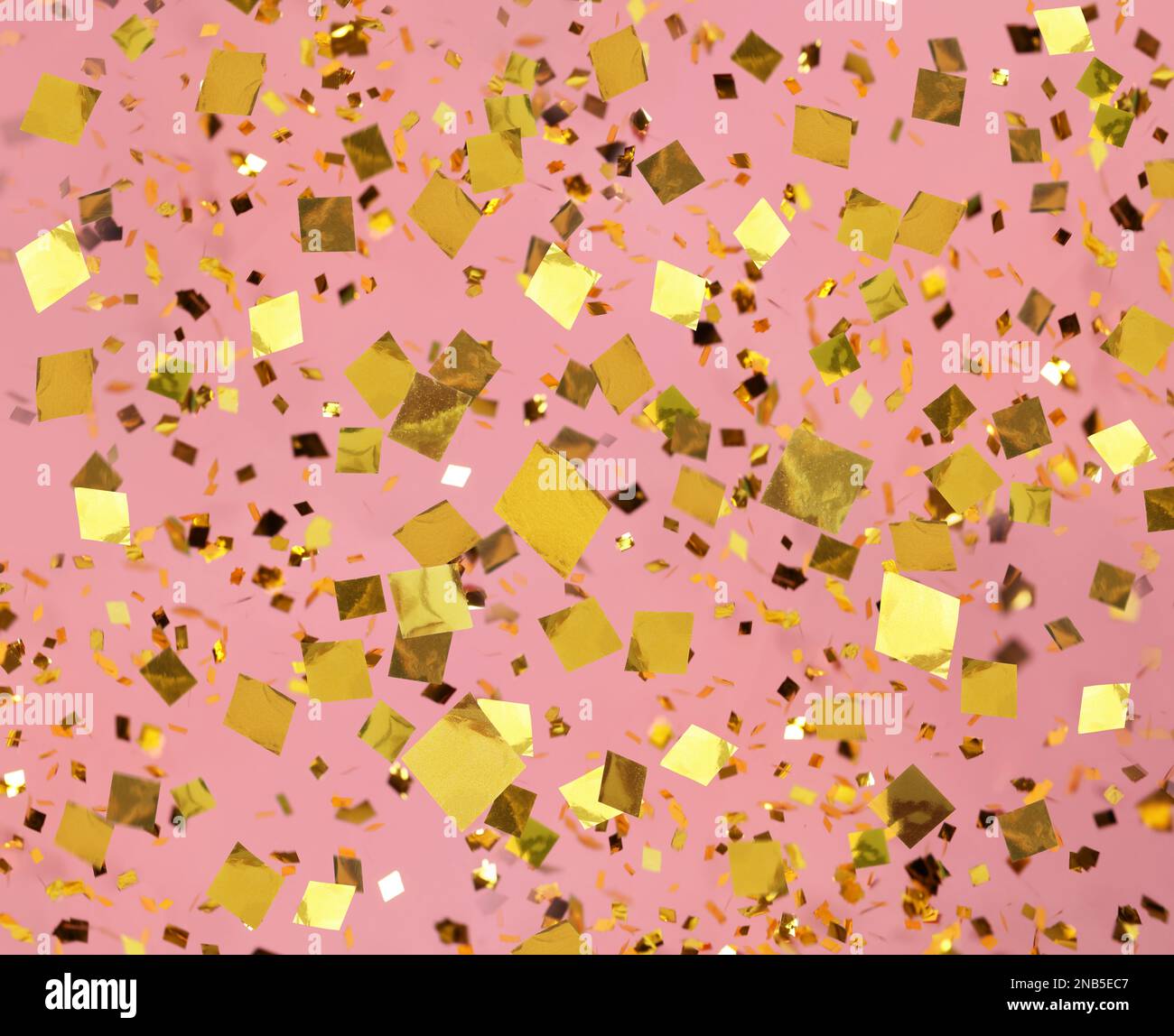 Shiny golden confetti falling down on pink background Stock Photo - Alamy