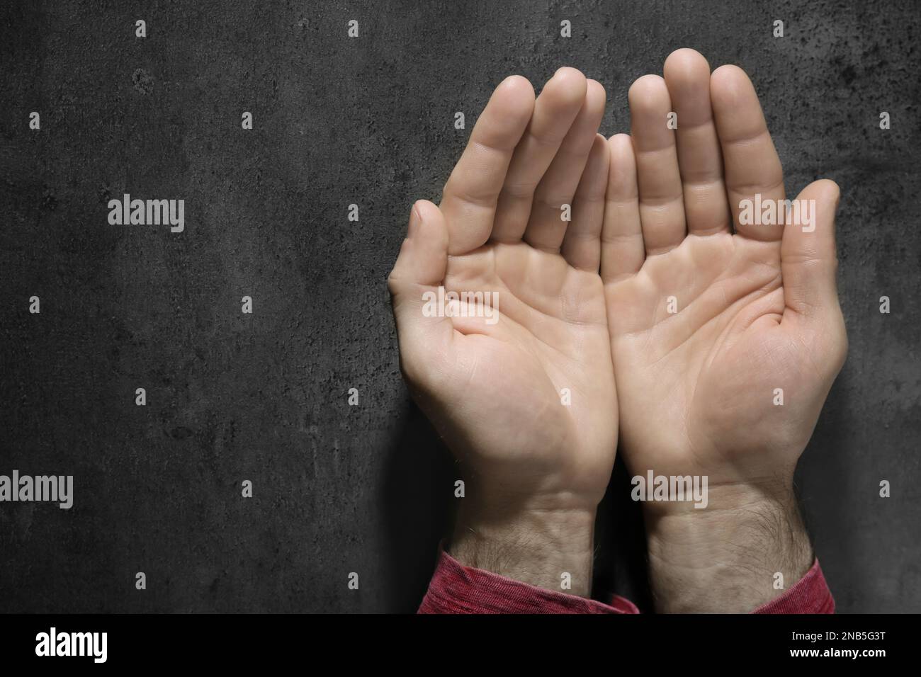 Man showing pale palms at grey table, top view with space for text ...