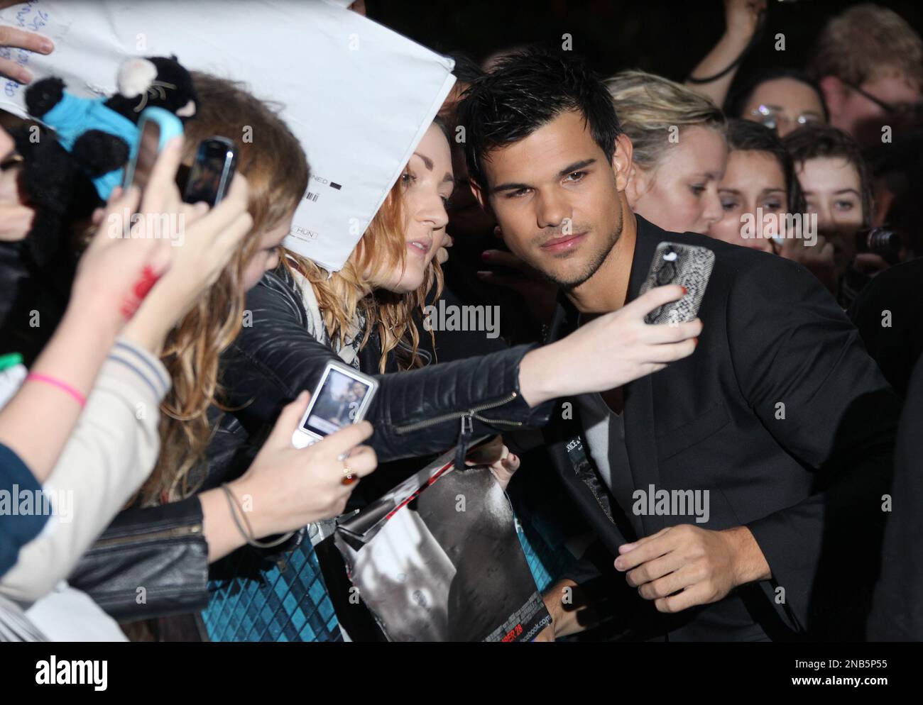 Actor Taylor Lautner poses with fans as he arrives on the red carpet in ...