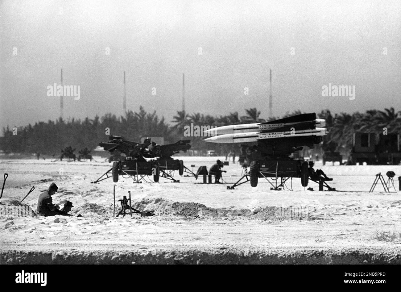 Two soldiers sit in a machine gun emplacement, left, on a beach at Key ...