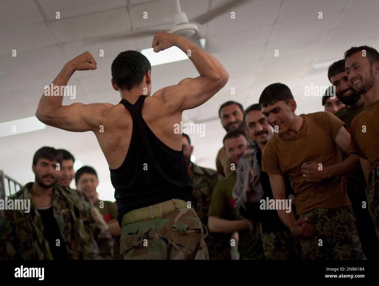 An Afghan National Army soldier shows his muscles to comrades inside ...