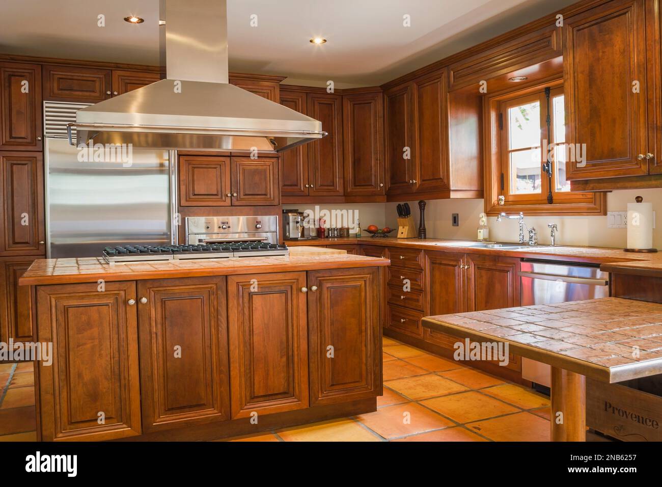 Maple wood cabinets and island with marble tile countertop in kitchen ...