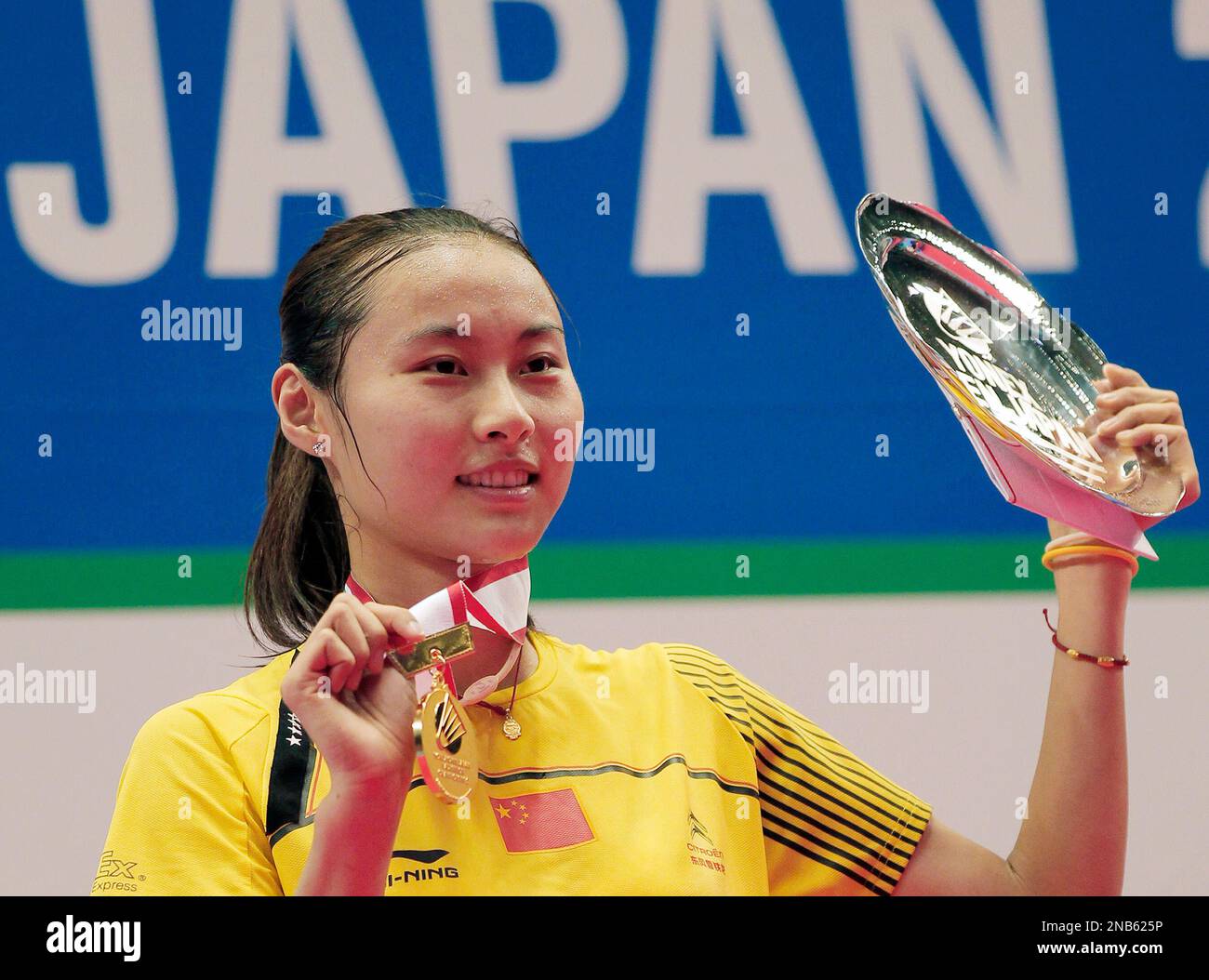 Wang Yihan of China holds her trophy during the awarding ceremony ...