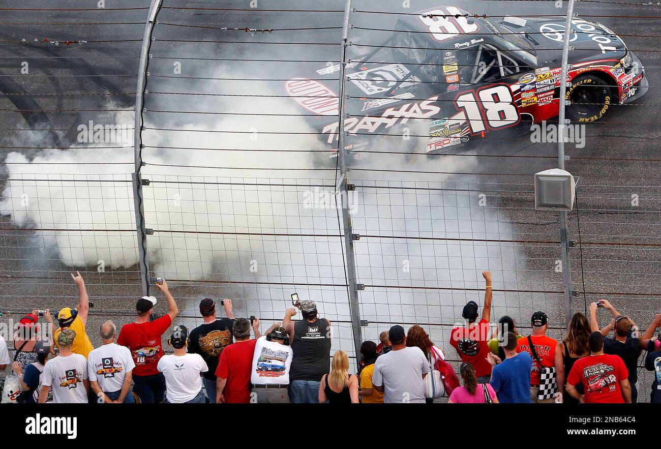 As fans cheer, Kyle Busch does a burnout at the finish line after ...