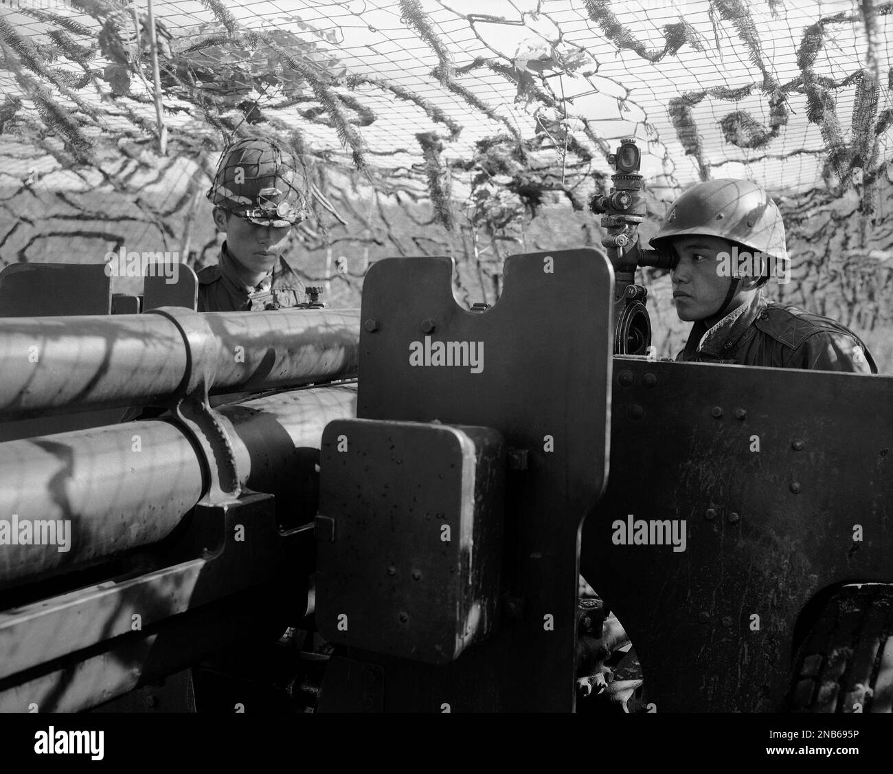 A 105mm howitzer is manned in a concealed emplacement by two Japanese ...