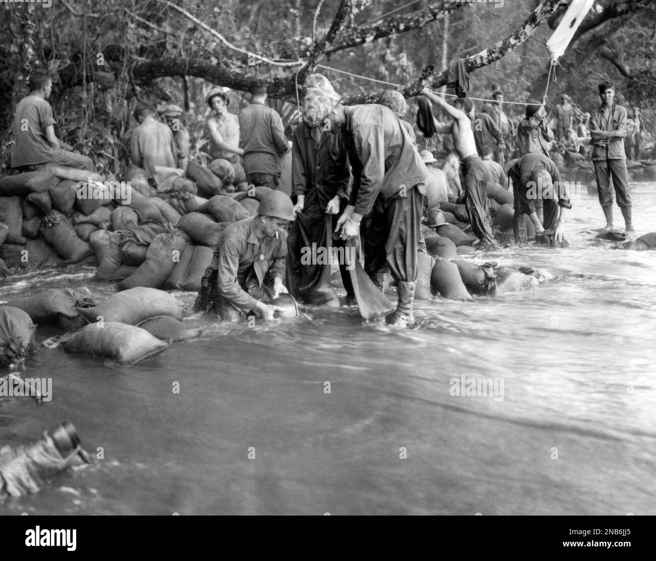 Sand-bag after sand-bag is filled by battle-wise Marines who have just ...