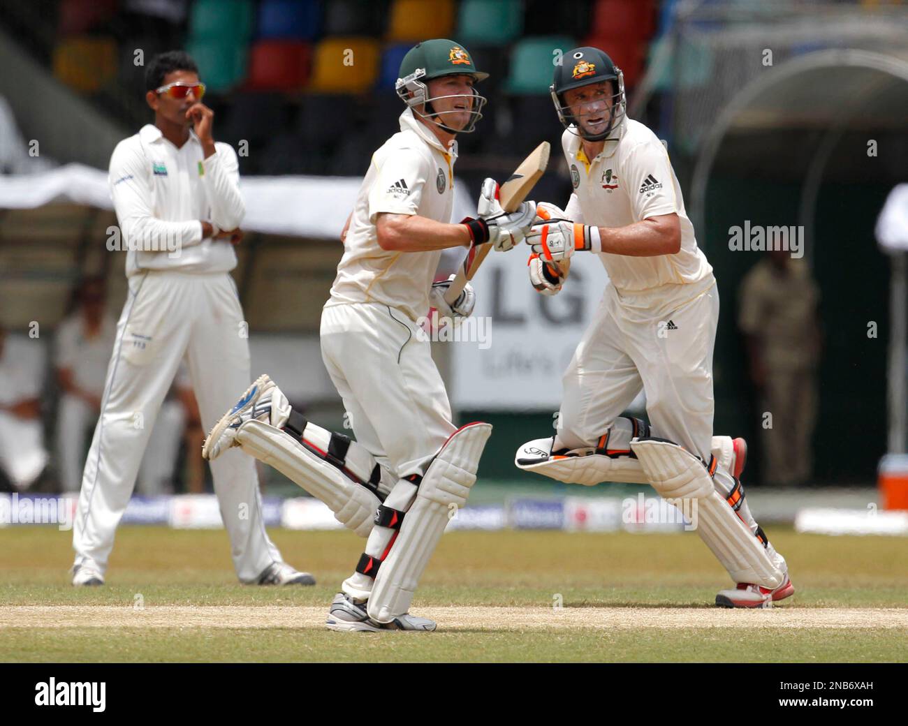 Australia's batsmen Michael Clarke, center, and Michael Hussey run ...