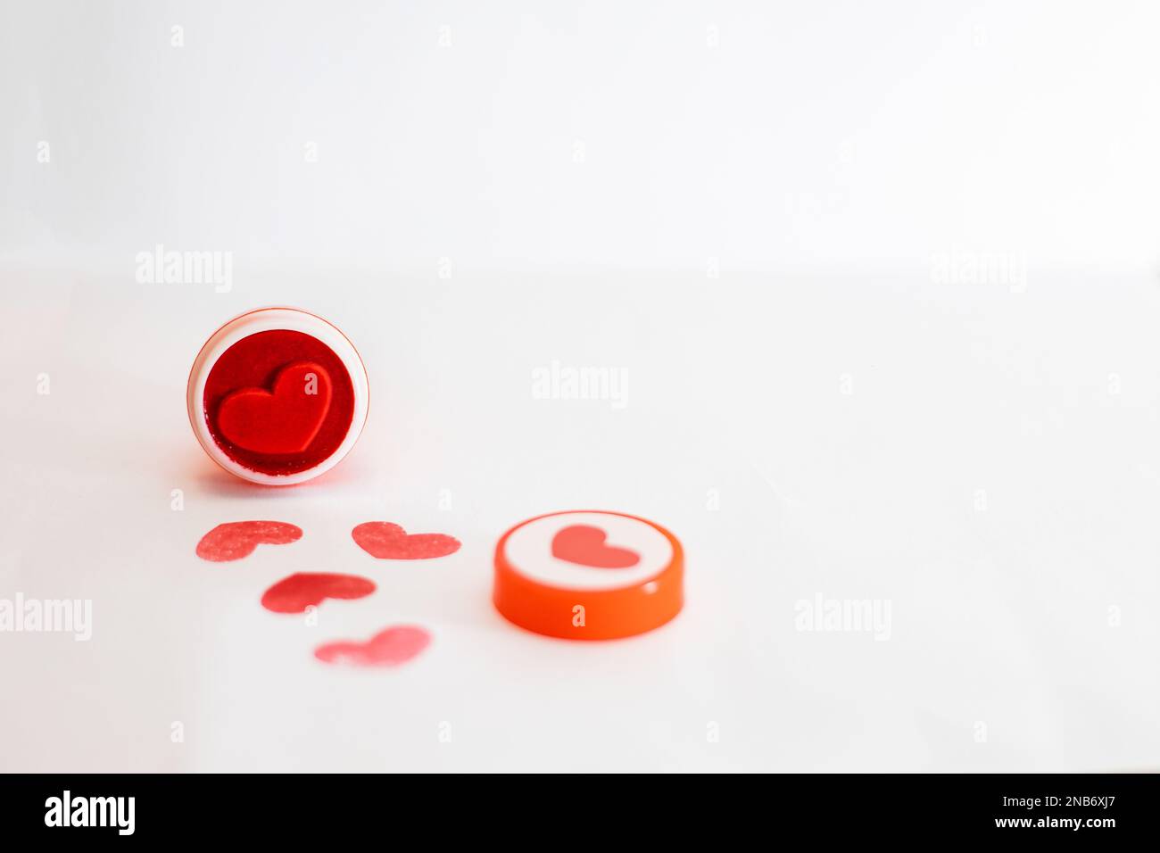 A stamp, in the shape of a red heart, next to ink marks, isolated on a ...