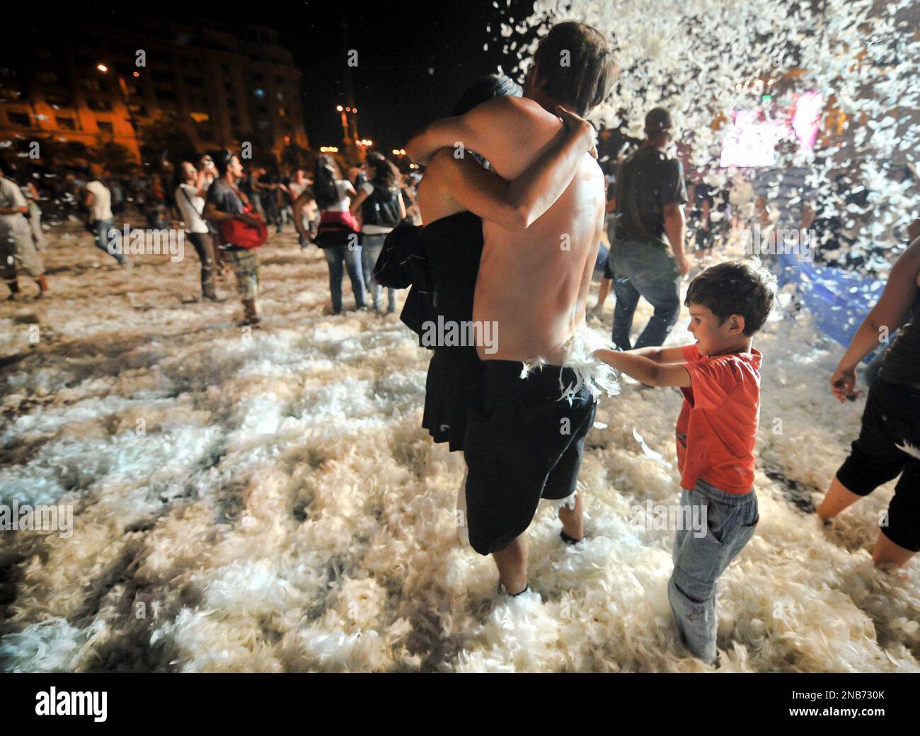 Andrei, 6-year old, enjoys the strewn feathers along with his father ...