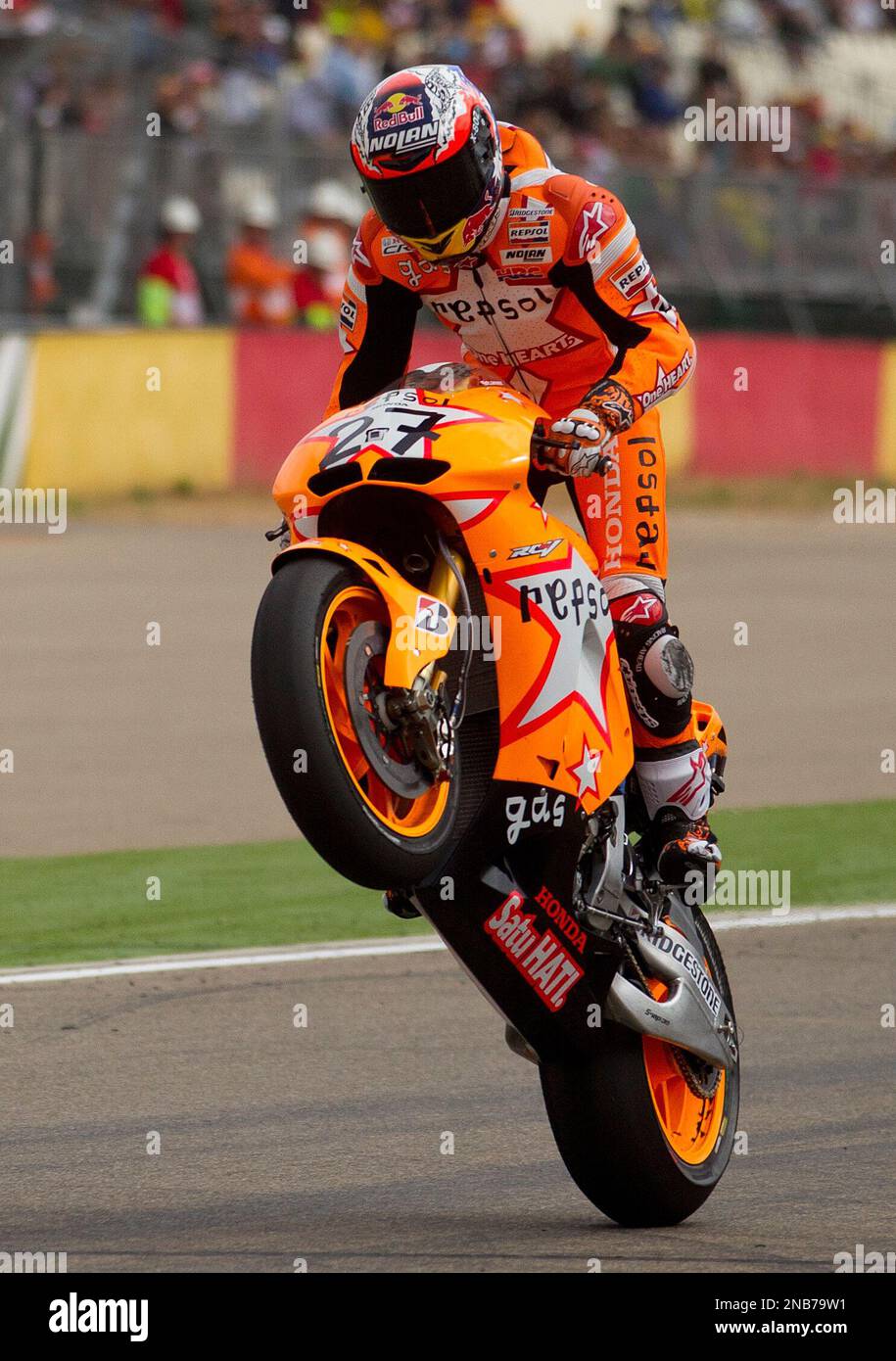 MotoGP Honda rider Casey Stoner of Australia does a wheelie as he ...