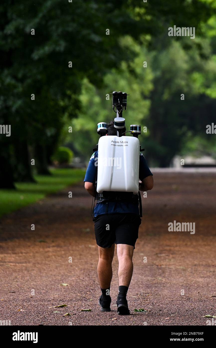 A man carries Apple Maps mapping equipment while walking through a park ...