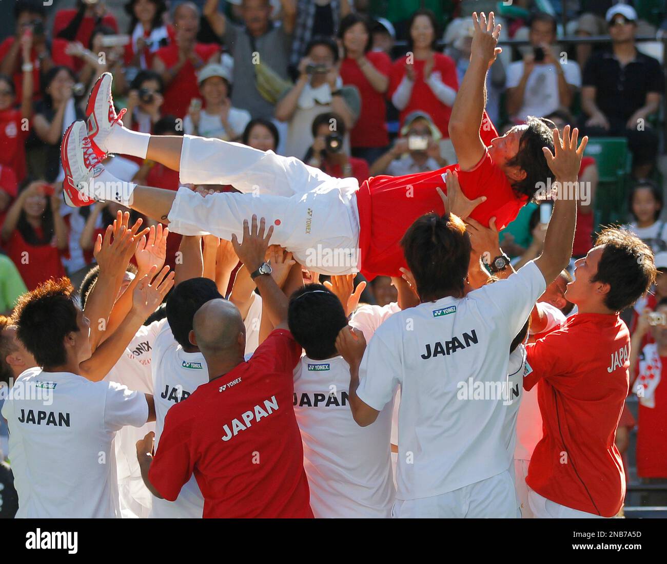 Japan's head coach Eiji Takeuchi is tossed in the air by Team Japan ...