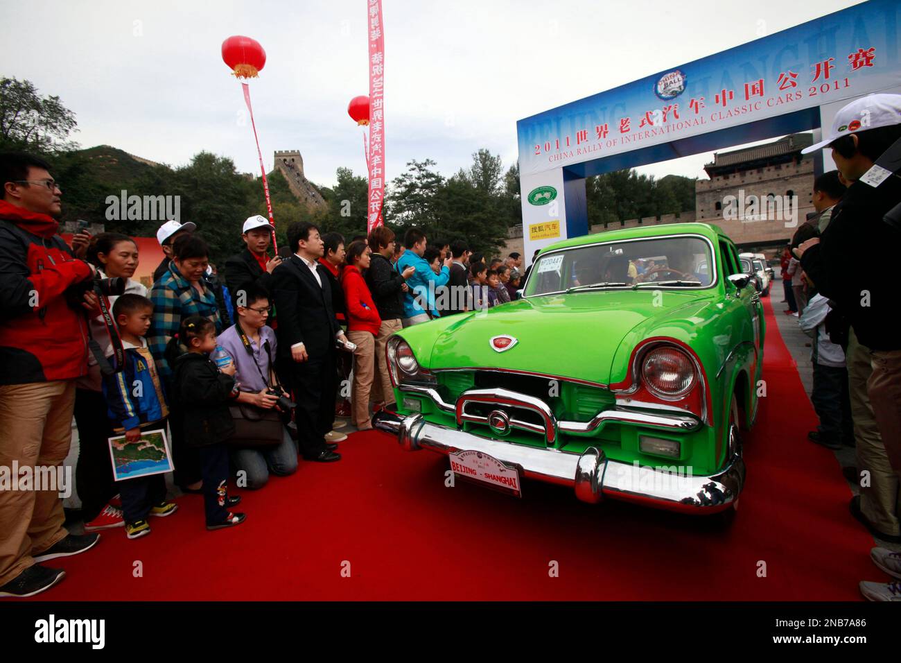 Spectators watch as a Chinese-made classic car takes part in the China ...