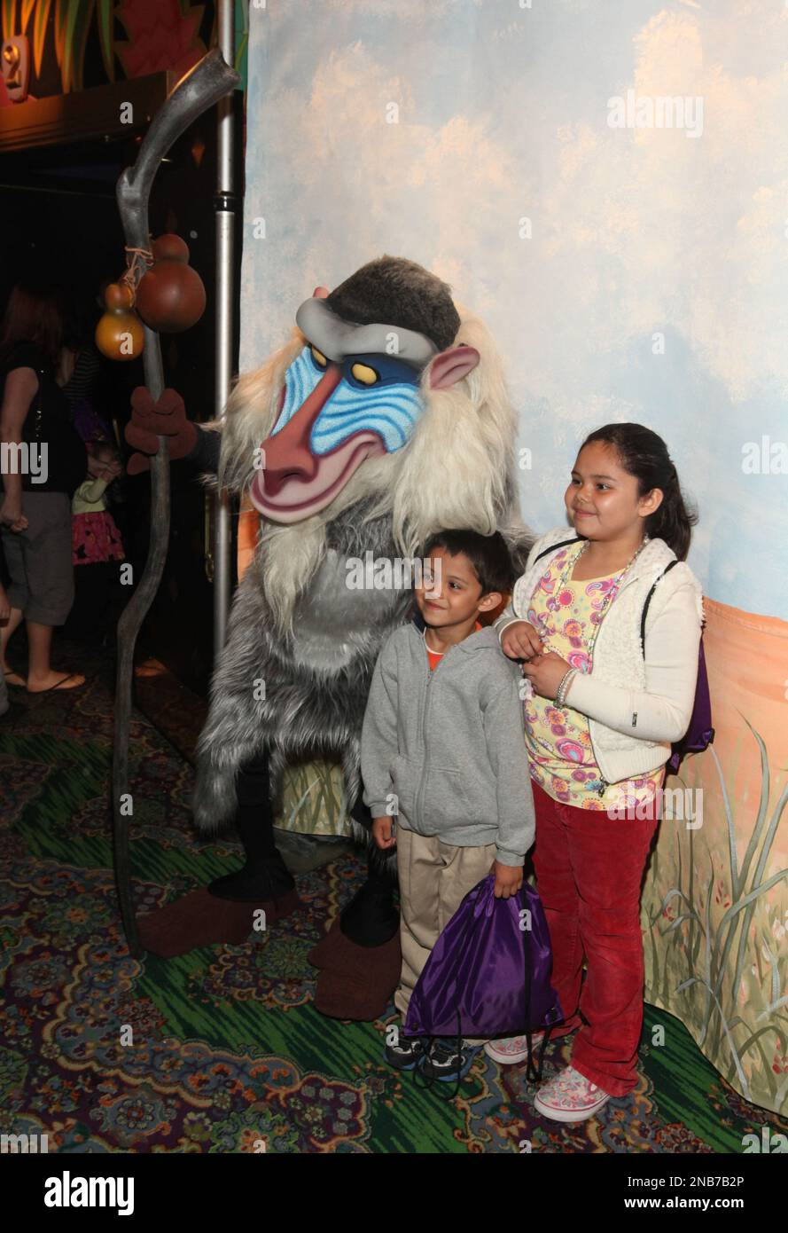 Guests pose with the Disney character Rafiki before a Time Warner Cable ...