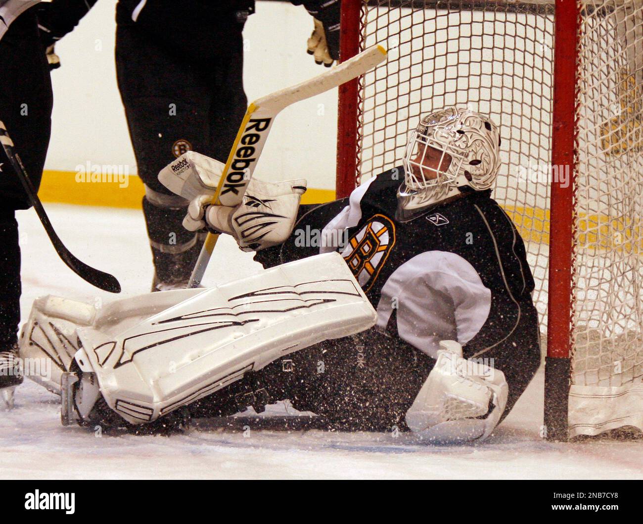 Boston Bruins goalie Tim Thomas slides into the net making a save ...