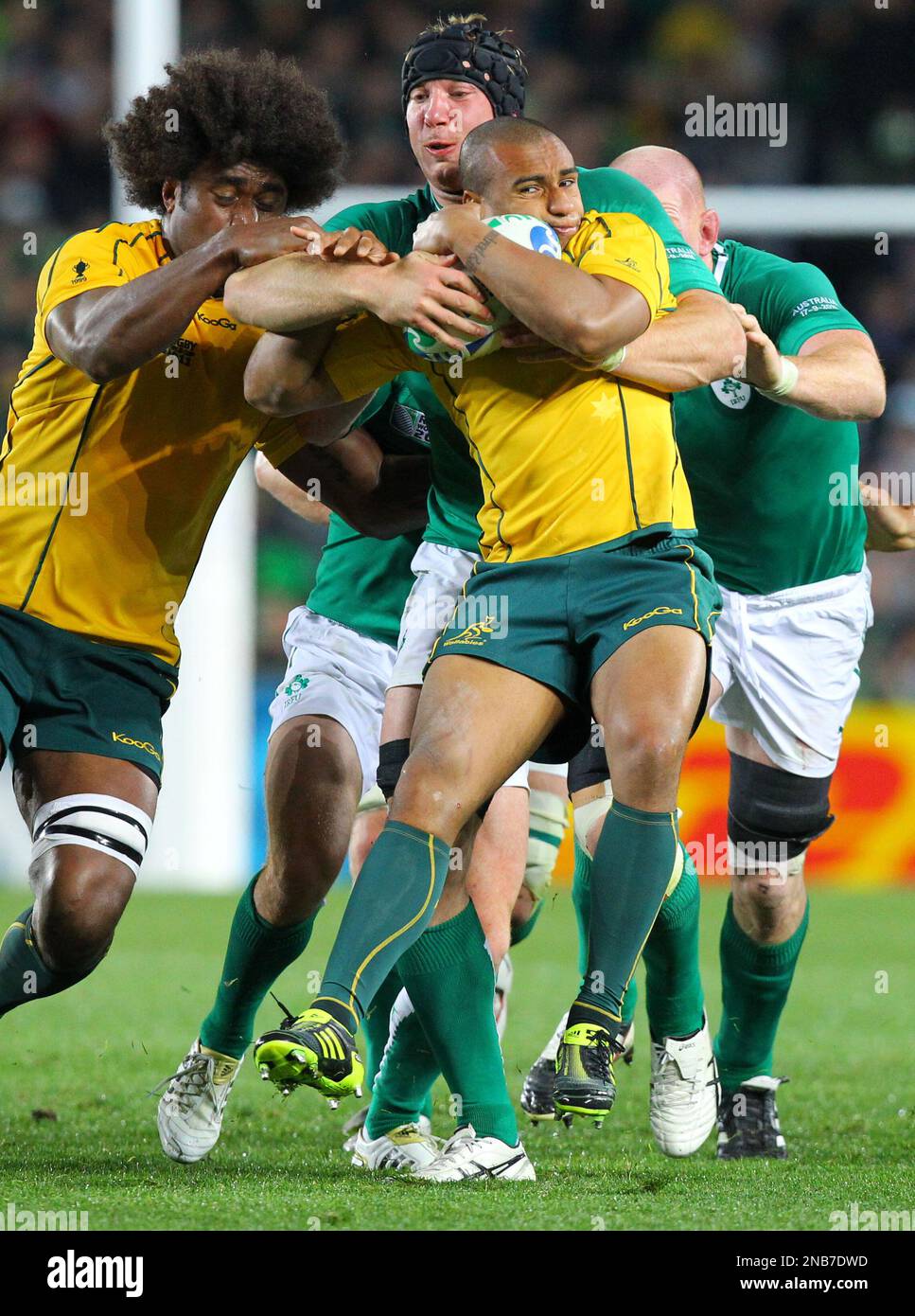 Australia's Will Genia, centre, is carried by Ireland's Stephen Ferris ...