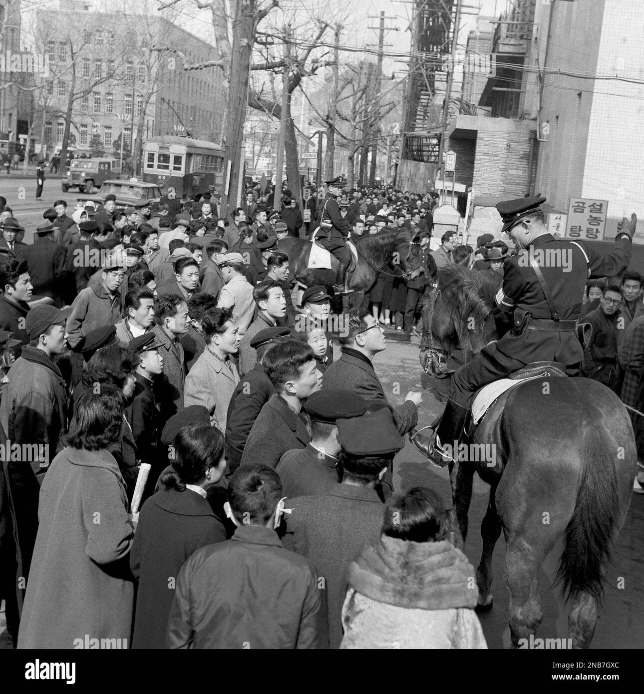 Mounted policemen and patrolmen have their hands full as milling crowd ...