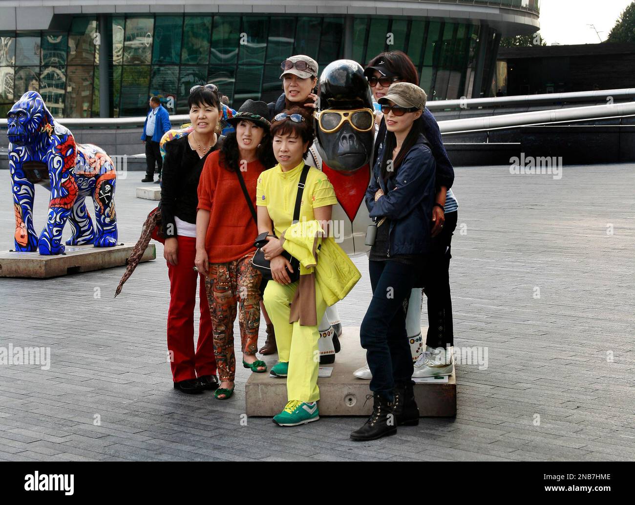 Tourists have their photo taken with an Elvis life-size gorilla model ...