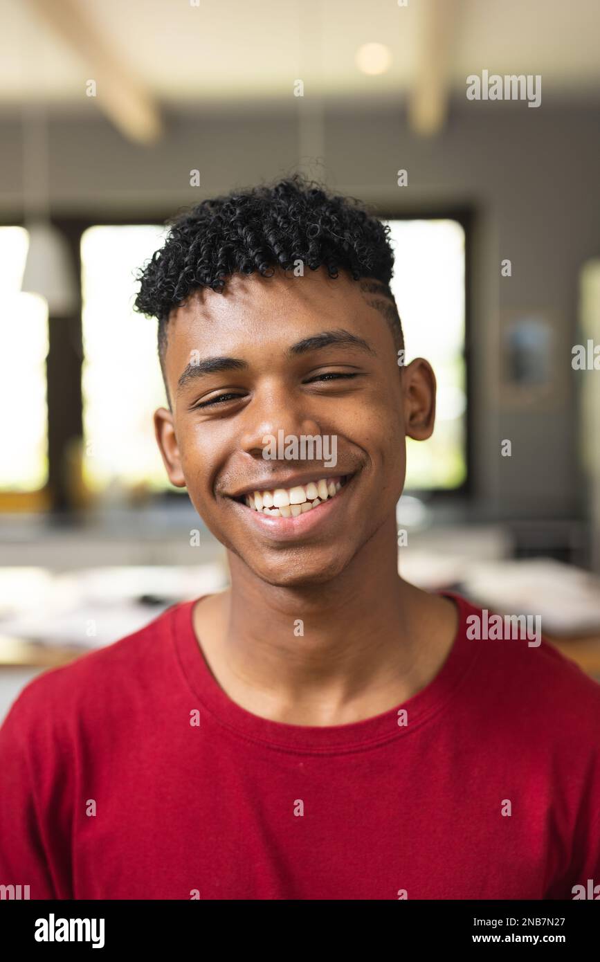 Vertical image of happy african american teenage boy looking at camera ...