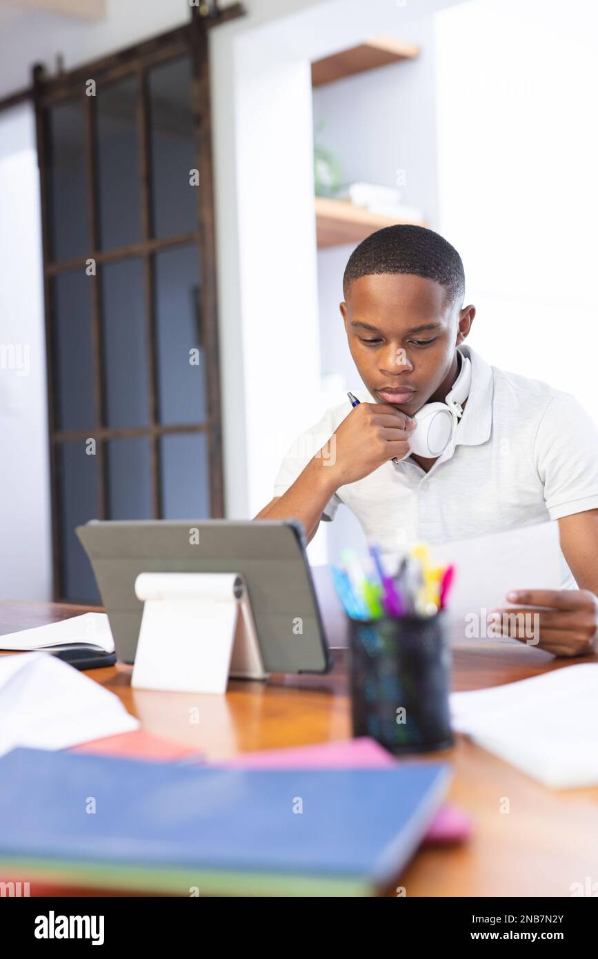 Vertical image of thoughtful african american teenage boy doing ...