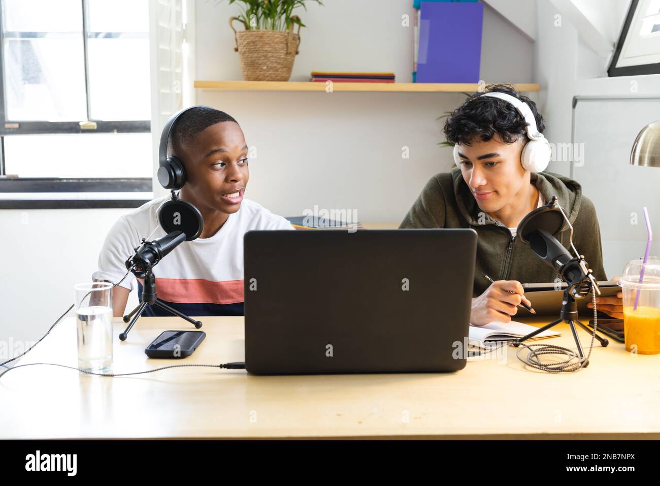 Diverse teenage male friends with headphones, microphone and laptop ...