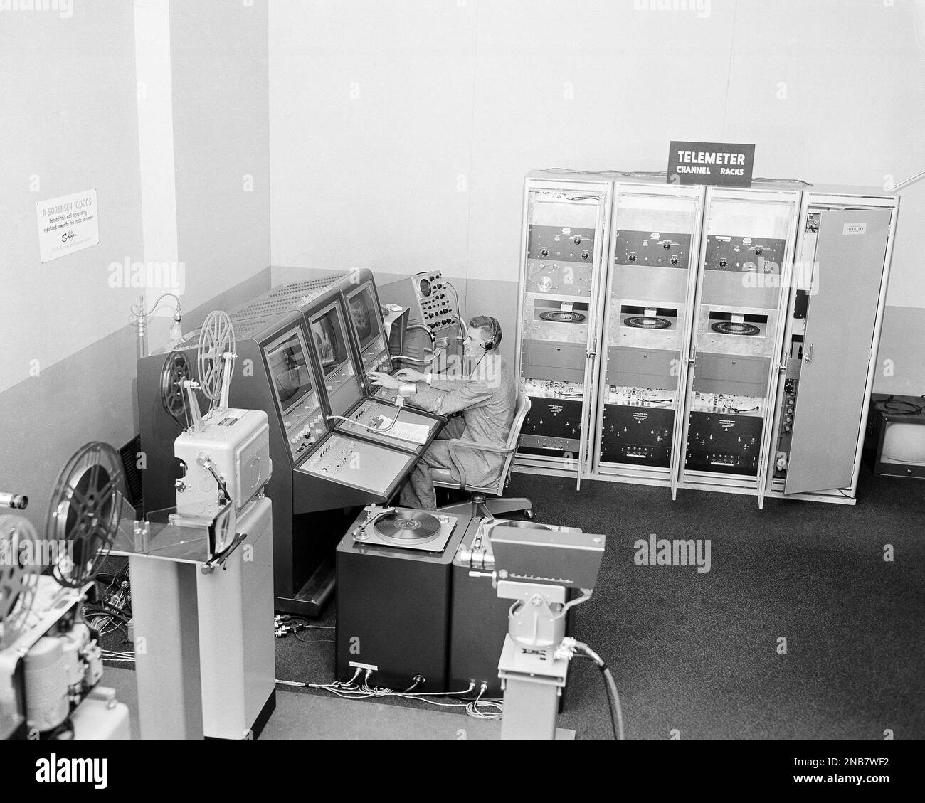 Jack Doze, an operating engineer, turns dials as he watches three TV ...