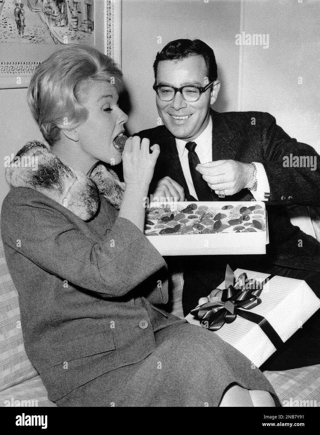 Producer Ross Hunter, watching happily as Doris Day consumes his gift ...