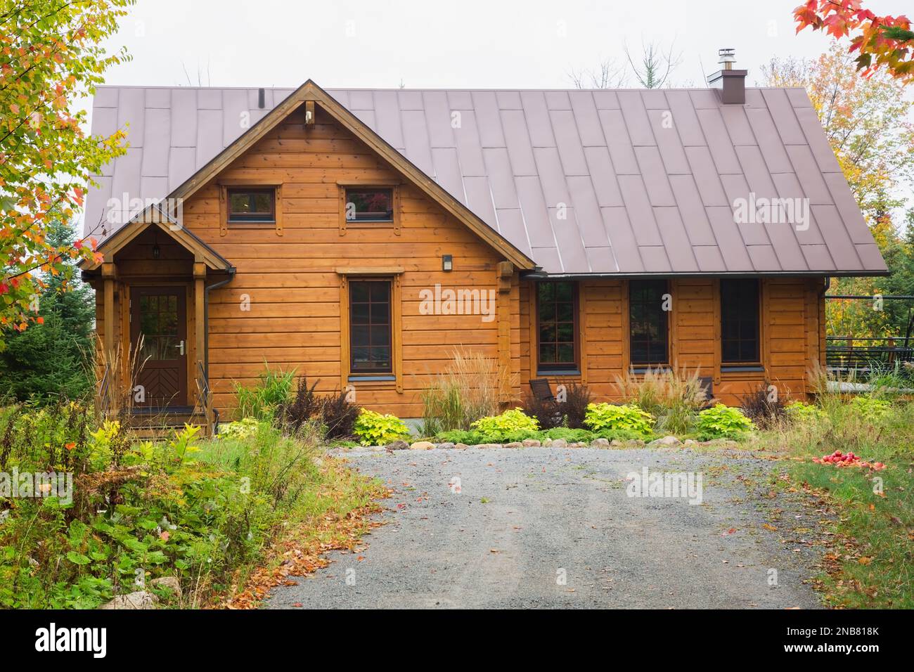 Piece sur piece Scots pine log home facade with brown standing seam ...