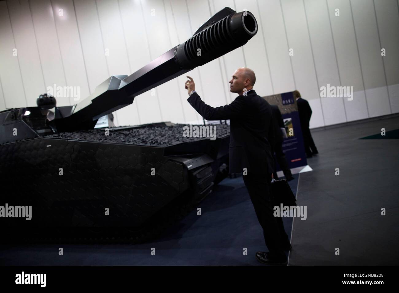 A man reaches out to touch a tank covered in a so called "invisibility ...