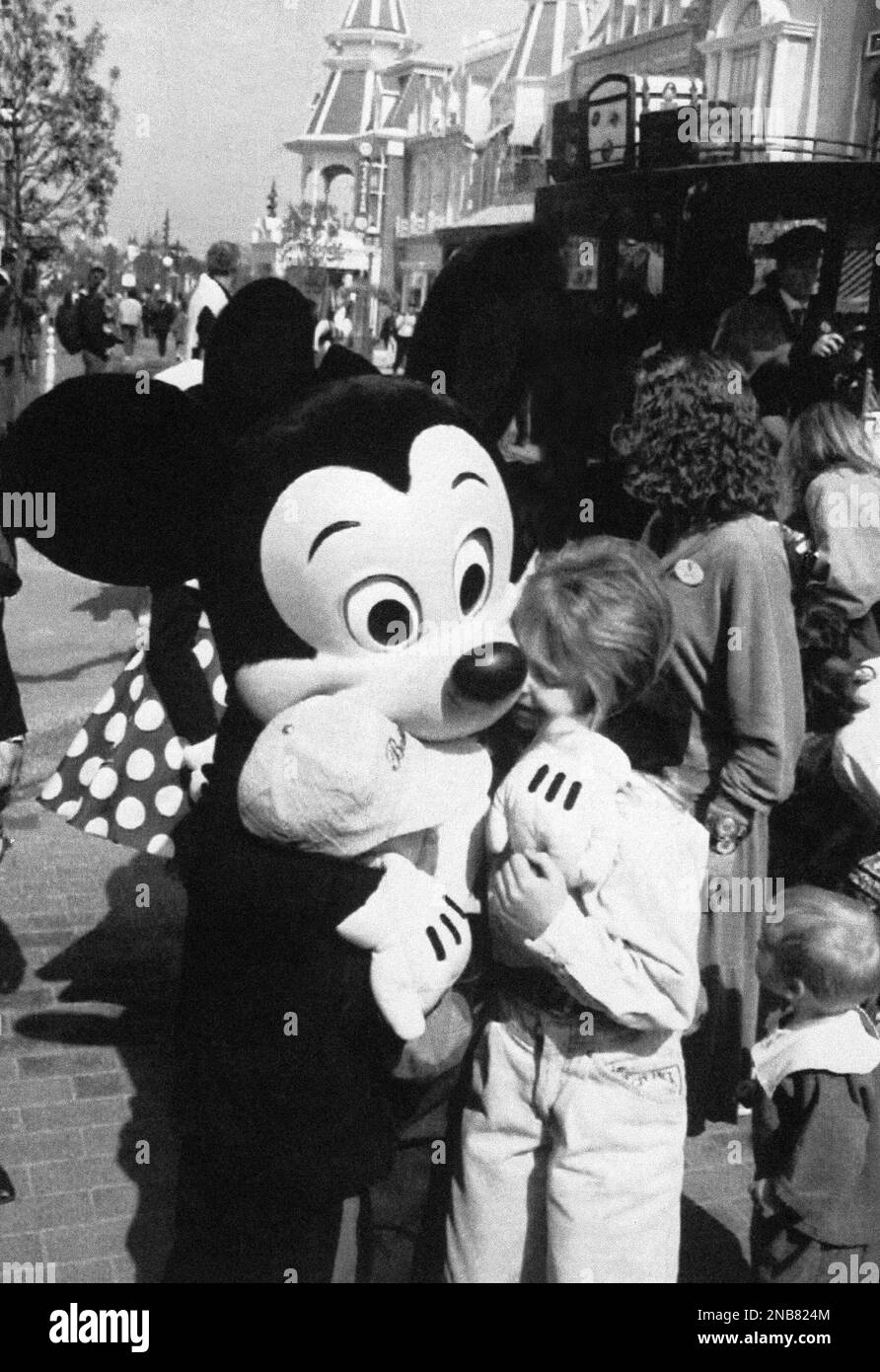 Two children get a hug from Mickey Mouse at the Euro Disneyland Park on ...