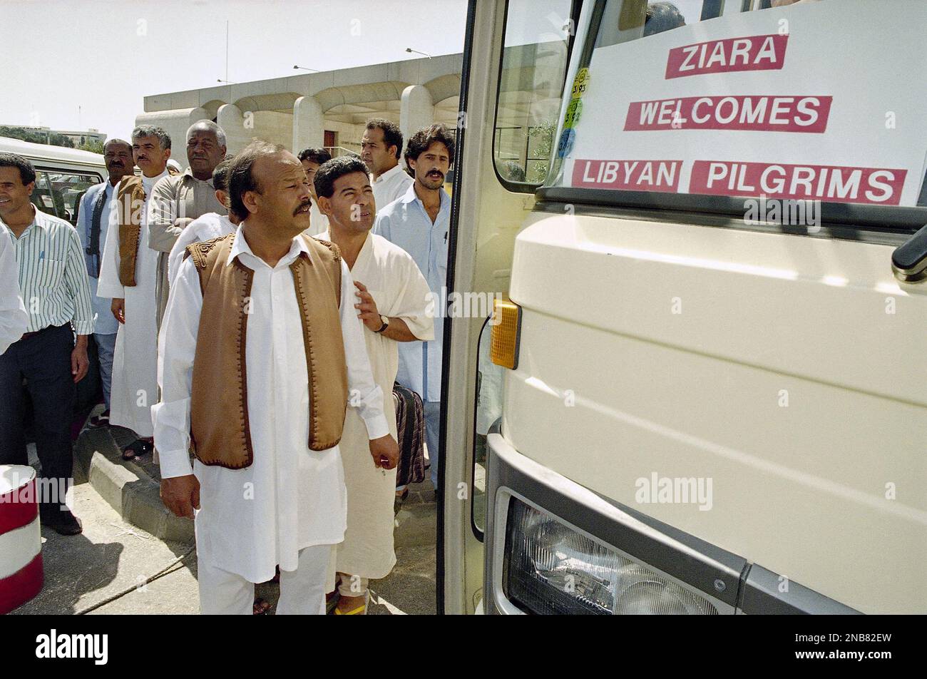 Libyan Muslim pilgrims line up to board a bus that will take them home ...